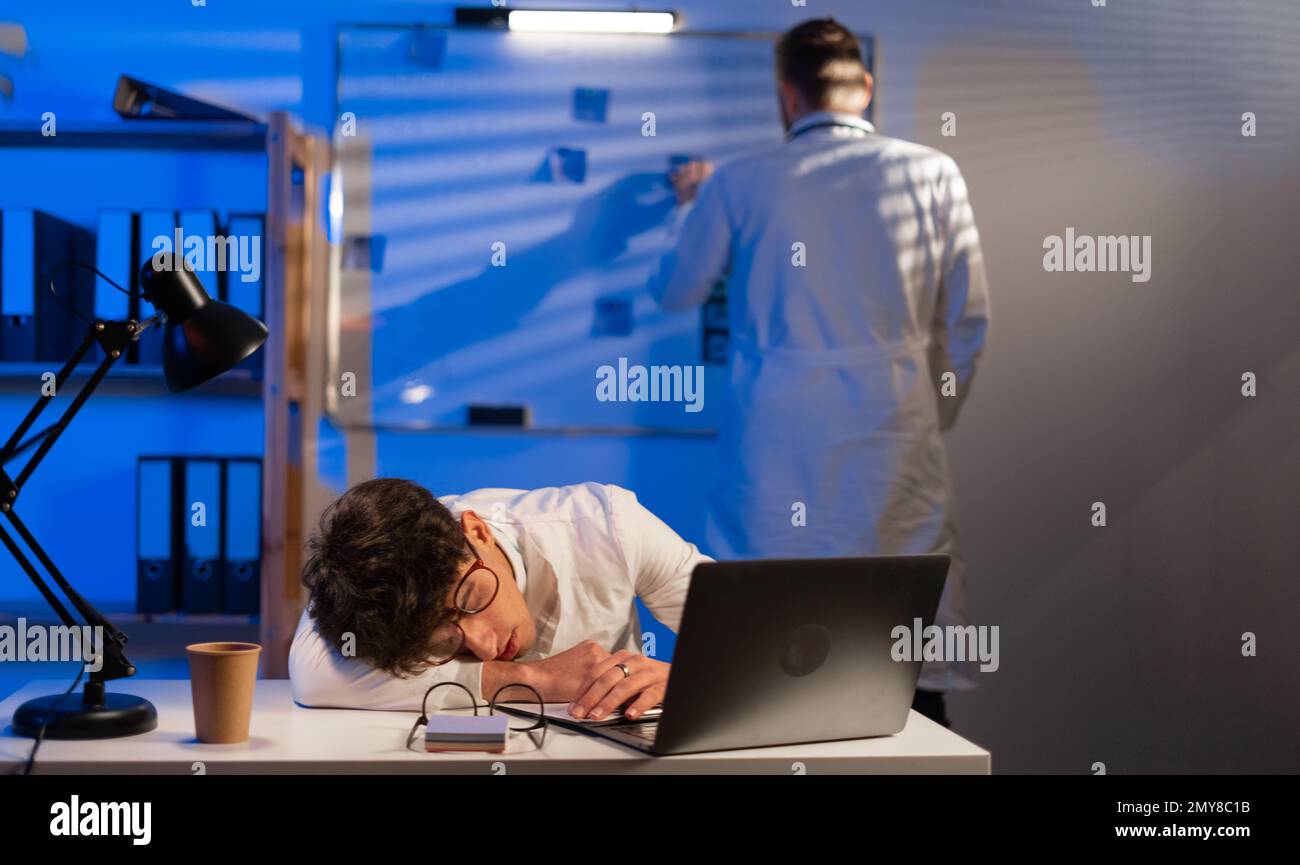 Tired doctor sleeping at the table during the night shift in the ...