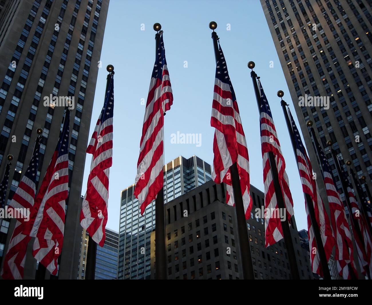 A low angle of the United States, USA flags against the skyline of ...