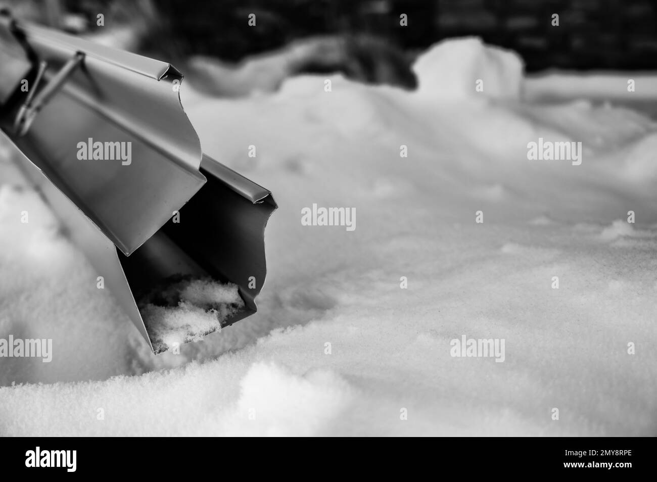 Section of new metal gutters laying on the ground with snow ready for ...