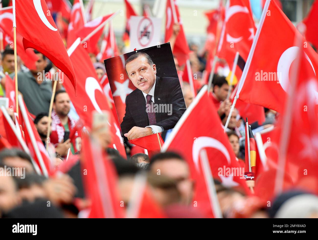 A picture of Turkish president Erdogan is framed by national flags ...