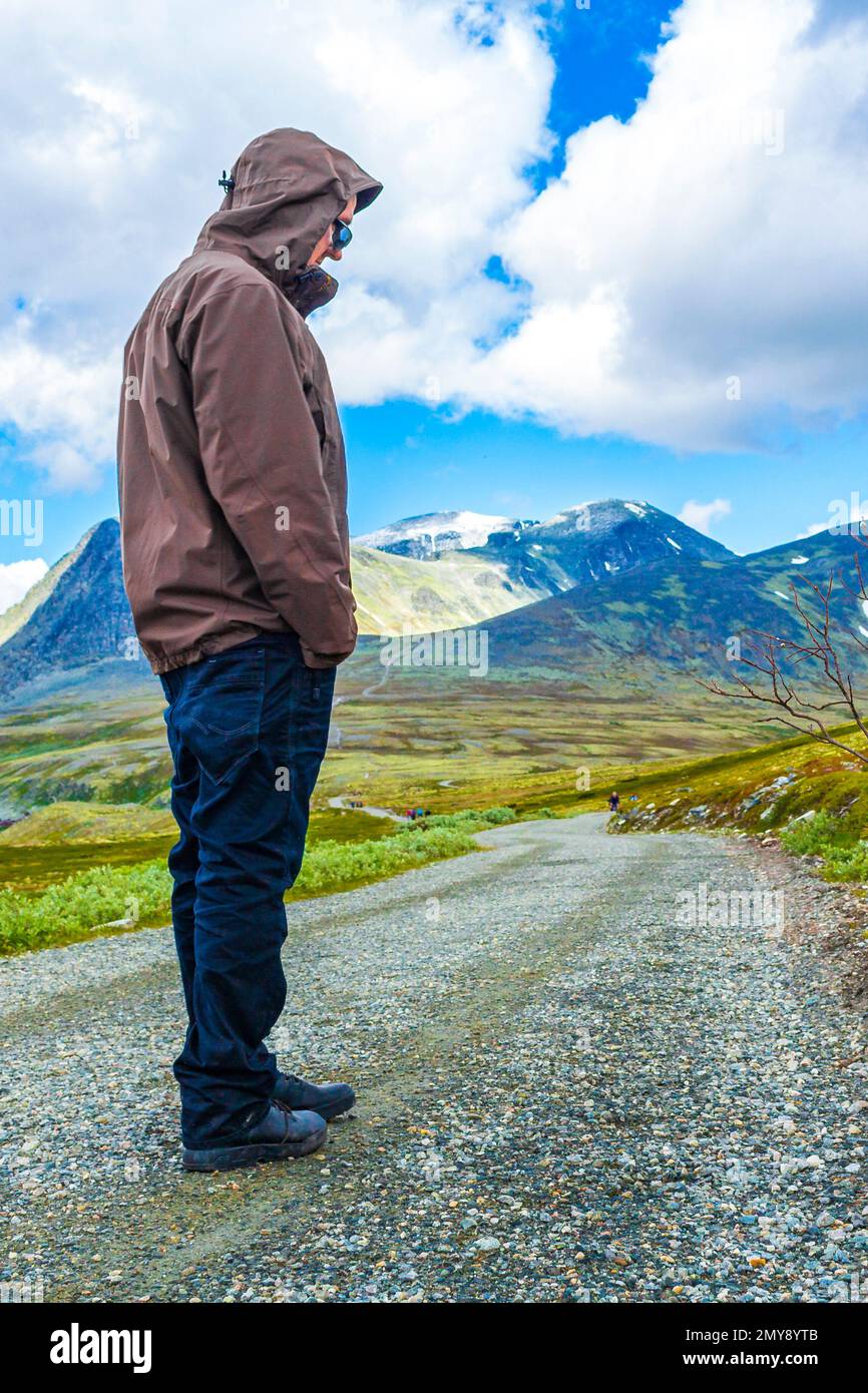 Lonely young hiker walks along hiking trail in landscape panorama ...