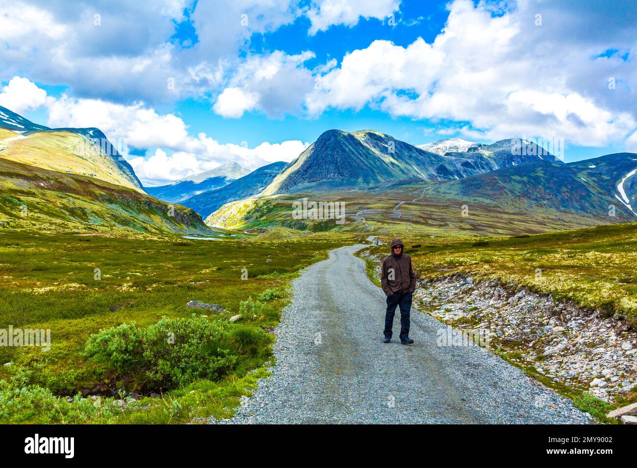 Lonely young hiker walks along hiking trail in landscape panorama ...