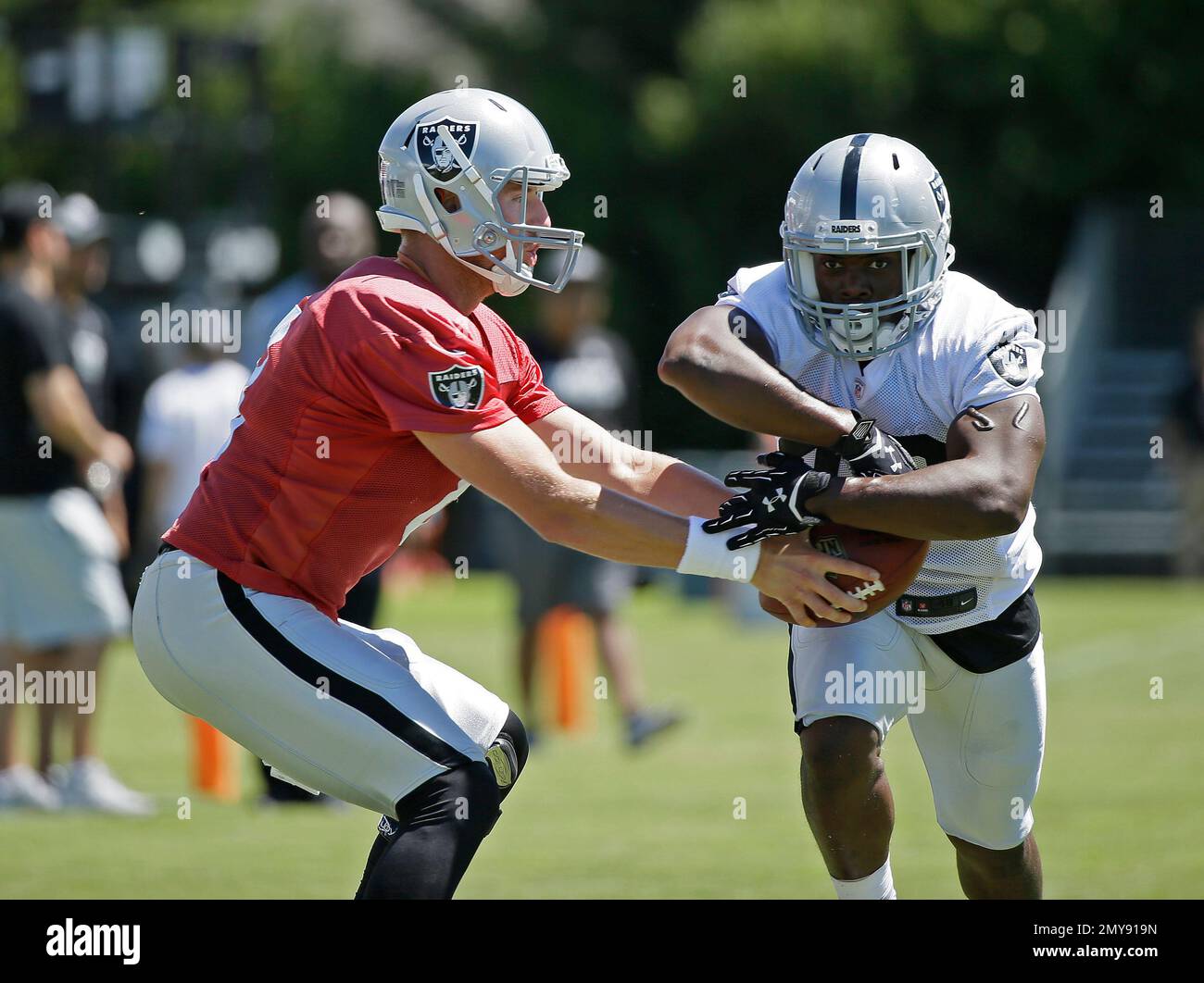 Oakland Raiders quarterback Connor Cook, left, fakes a hand off to ...