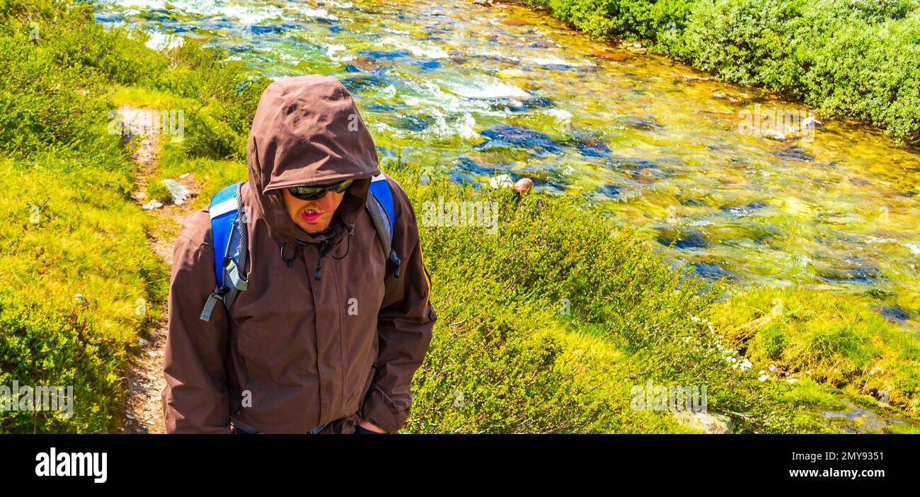 Lonely young hiker walks along hiking trail in landscape panorama ...
