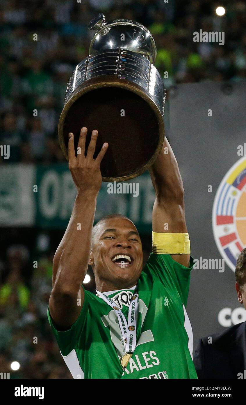 Alexis Henriquez of Colombia's Atletico Nacional raises the trophy as ...