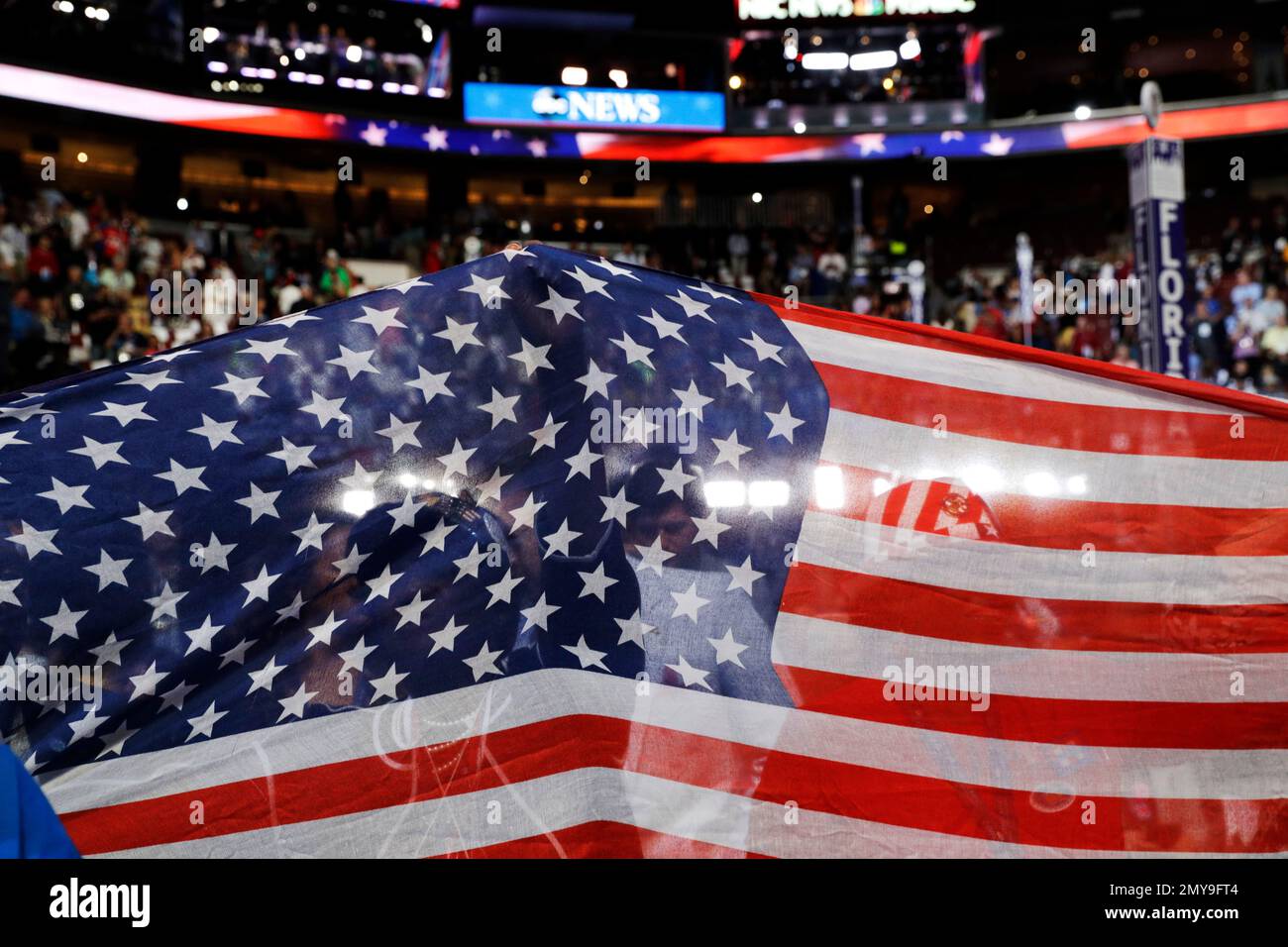 Florida delegates hold up a flag during the national anthem during the ...