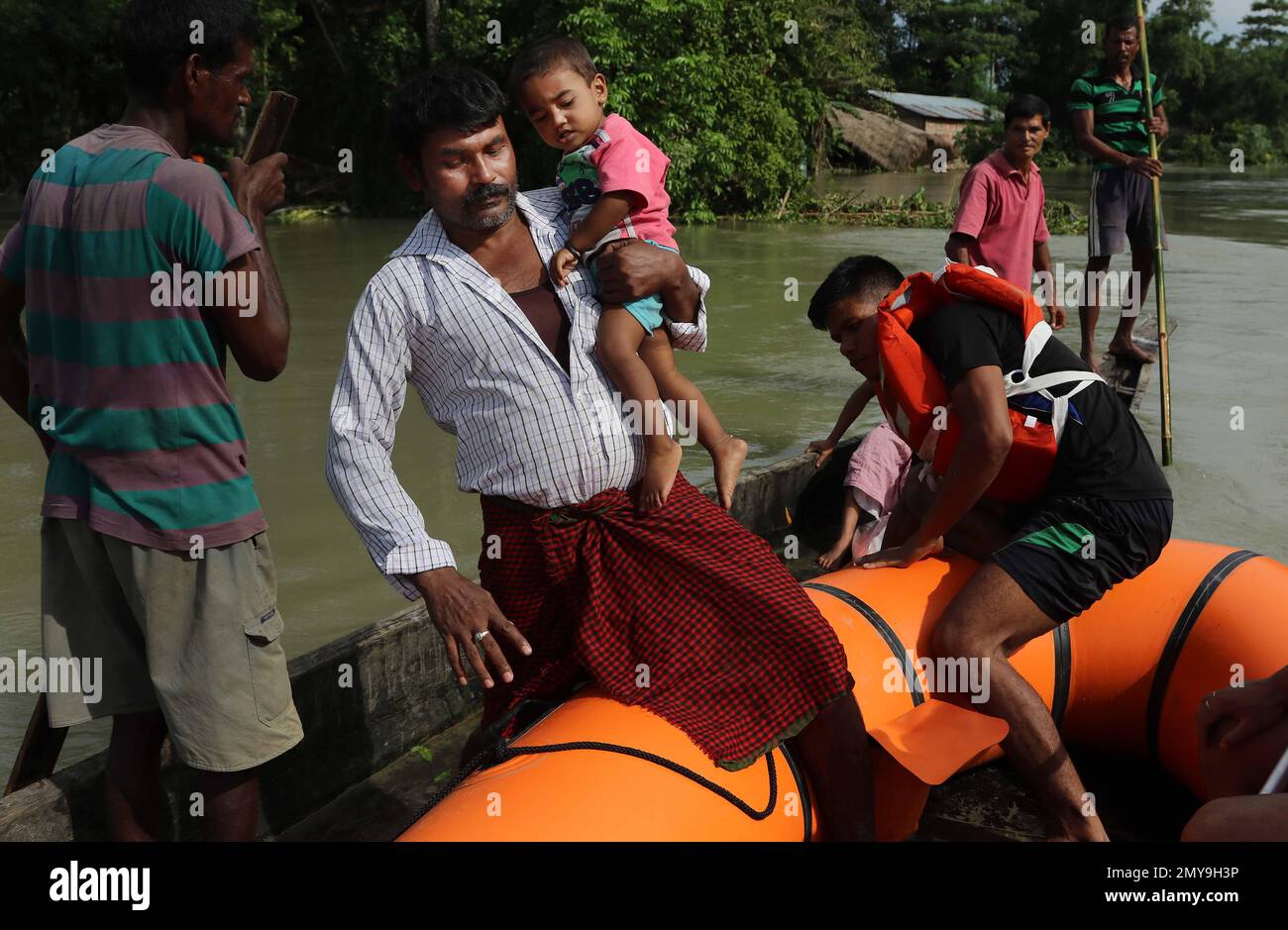 Rescuers help a flood affected Indian family get down from a boat at ...