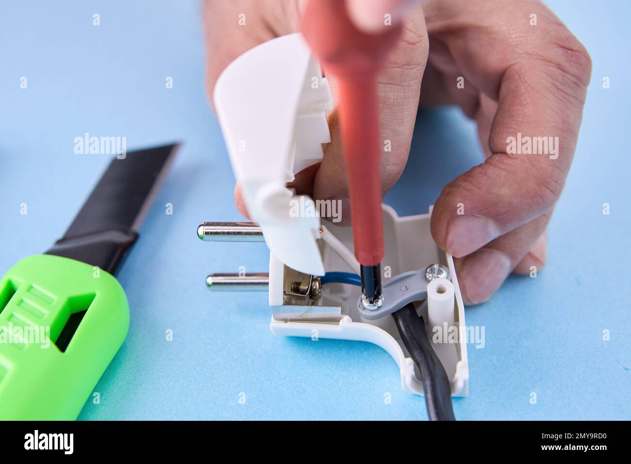 Electrical cord is connected to folding electric plug and secured with ...