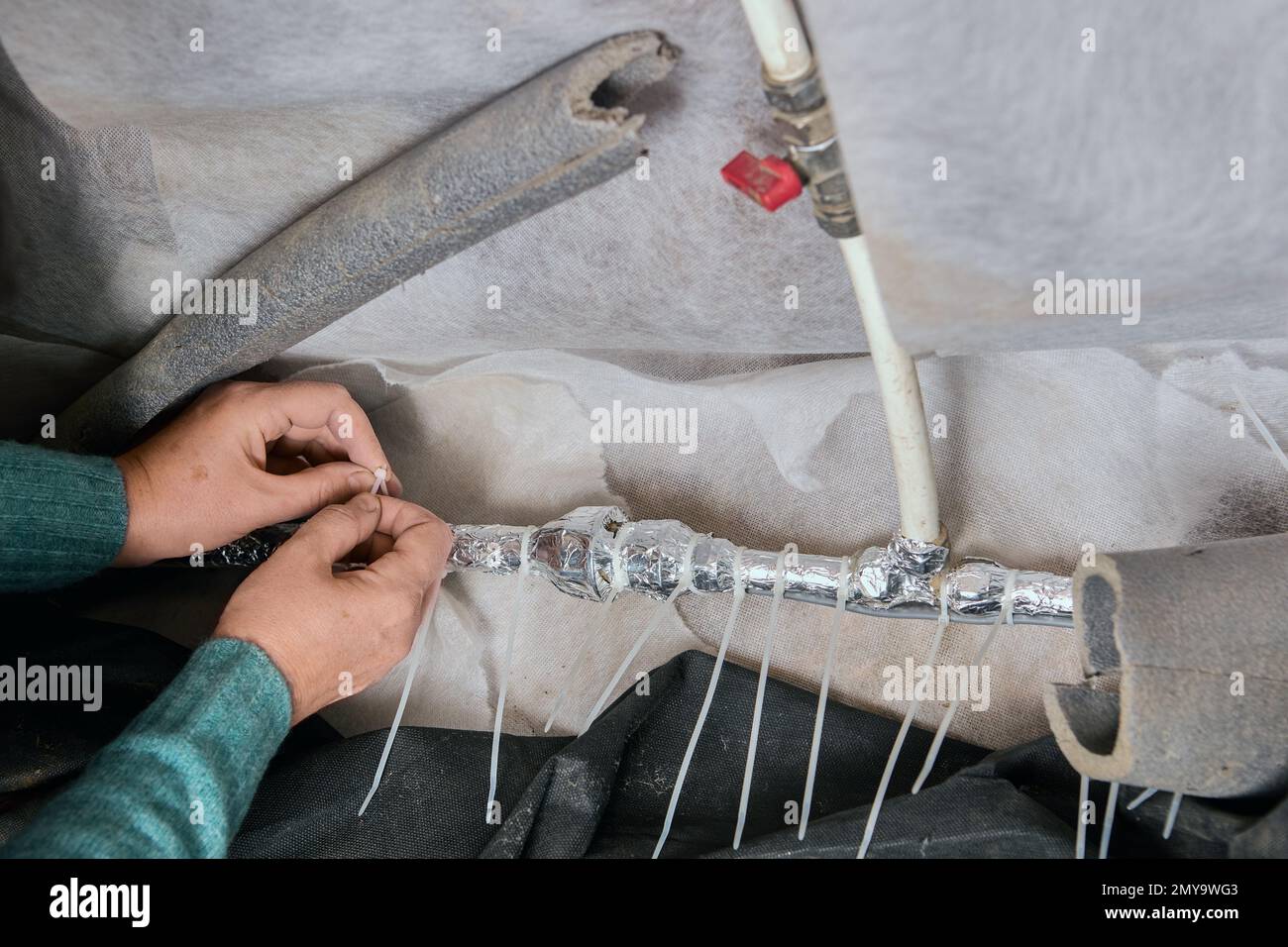 Installing of heating tape for home plumbing system in rural house ...