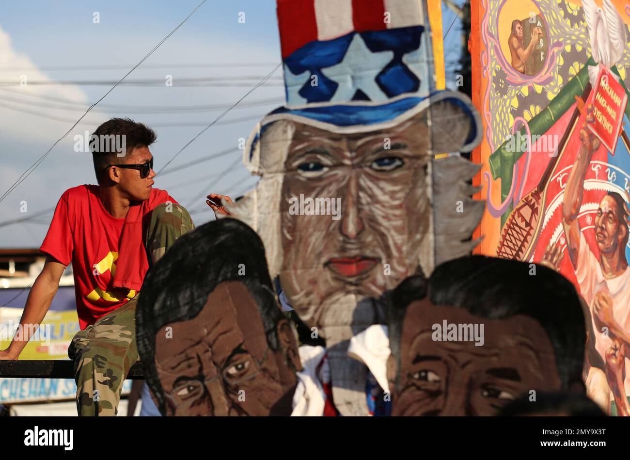 A Filipino activist sits beside an image of Uncle Sam as he joins a ...