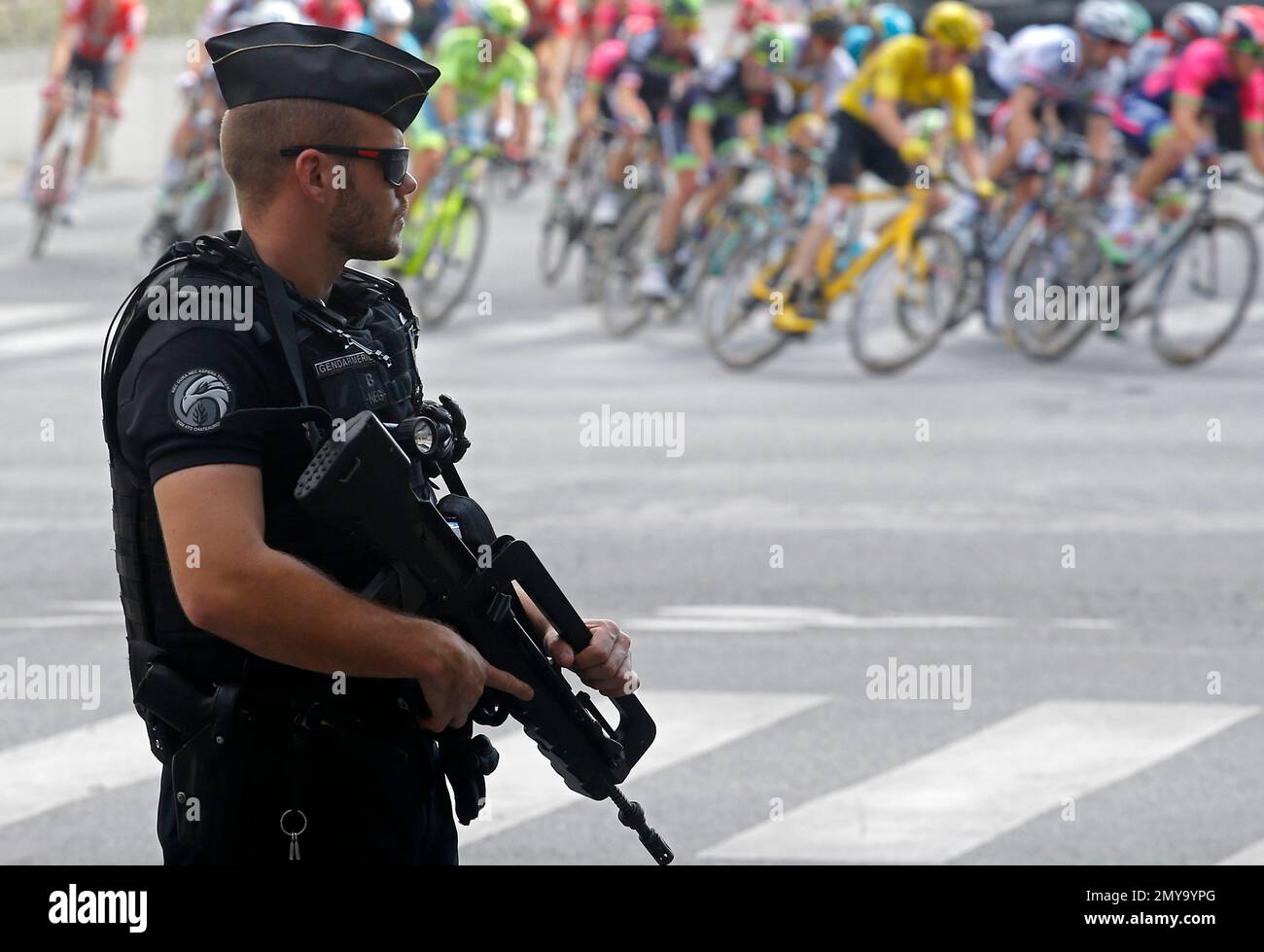 A French gendarme holds his weapon as the pack with Britain's Chris ...