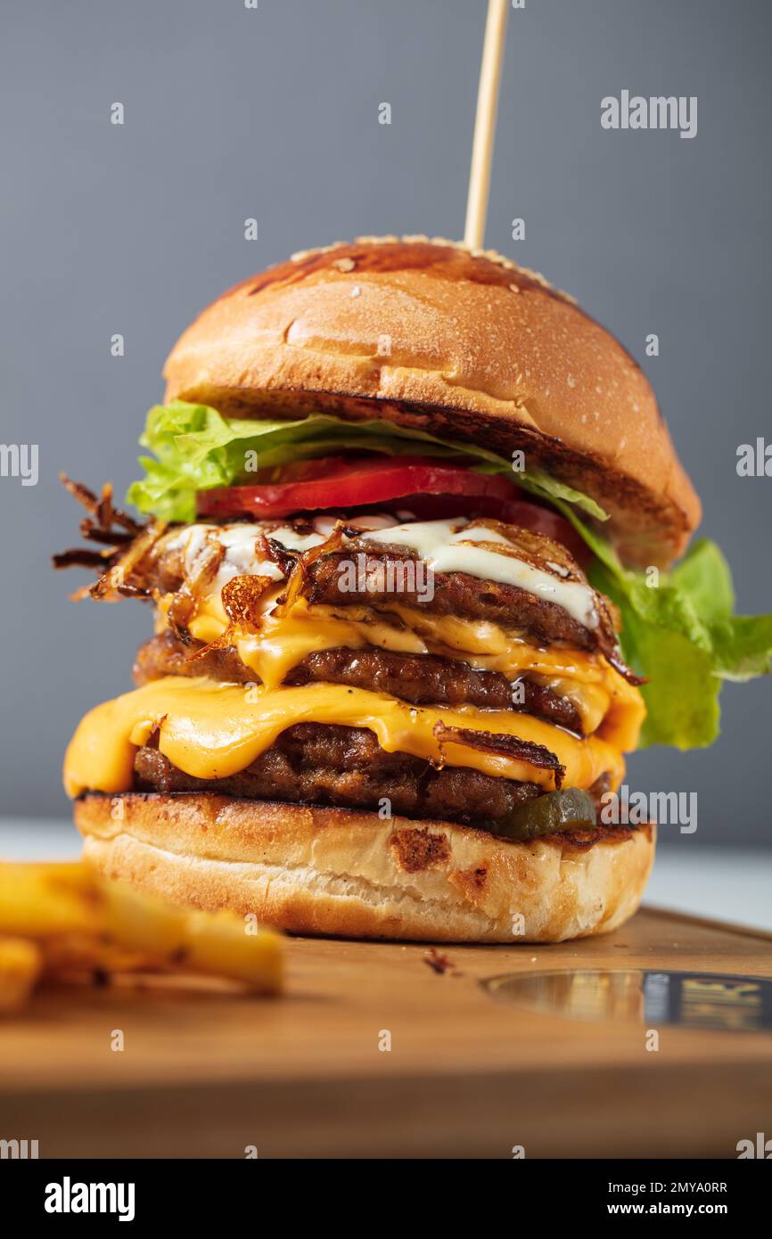 Loaded cheeseburgers three triple, stacked patties stacked high with ...