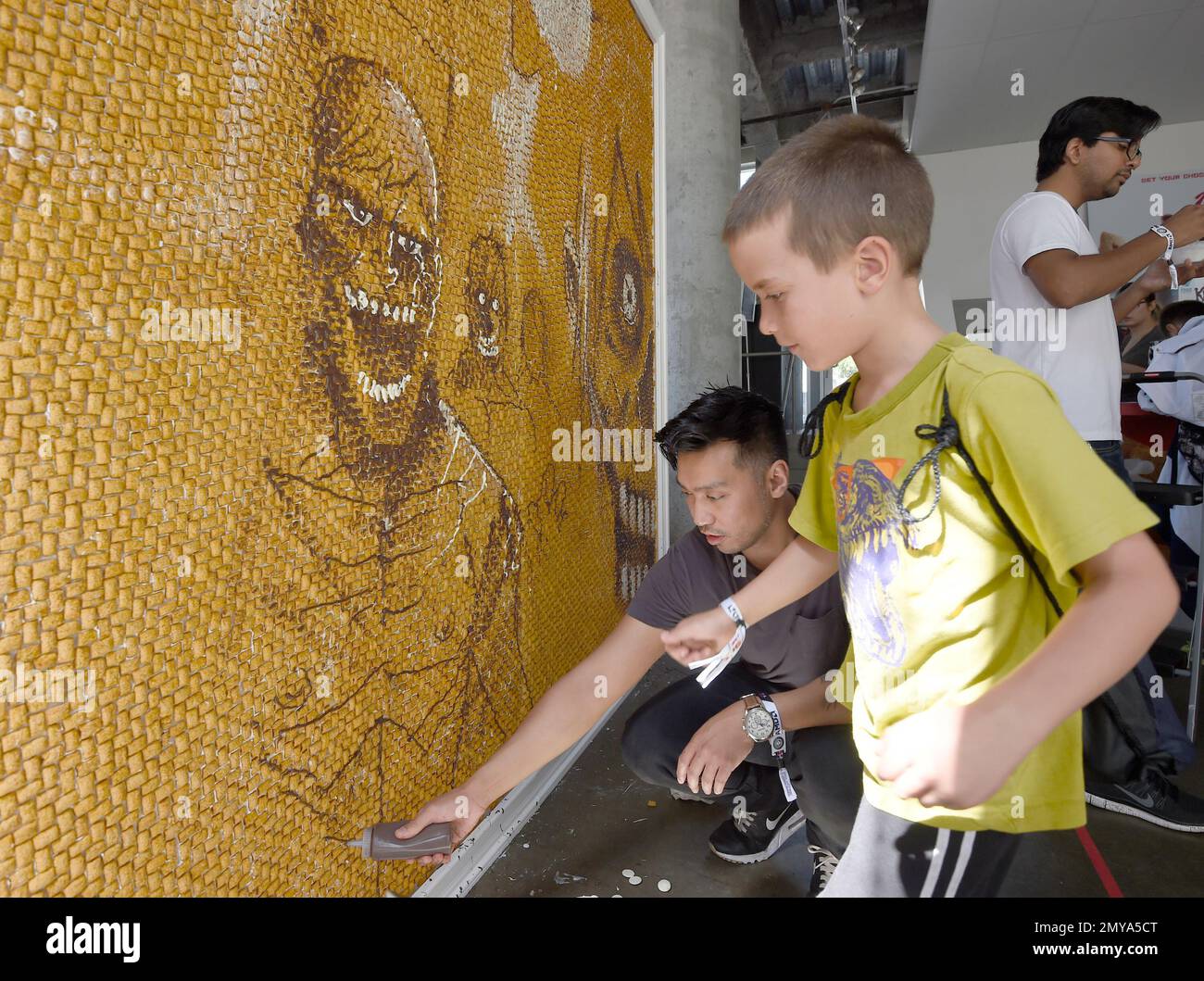 Eight-year-old Nicholas Mckee assists comic illustrator Francis Manapul ...