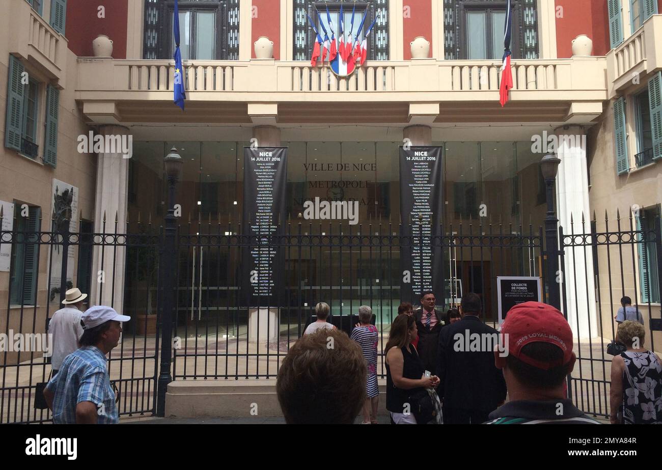 People look through the gates of the Nice City Hall in Nice, France ...