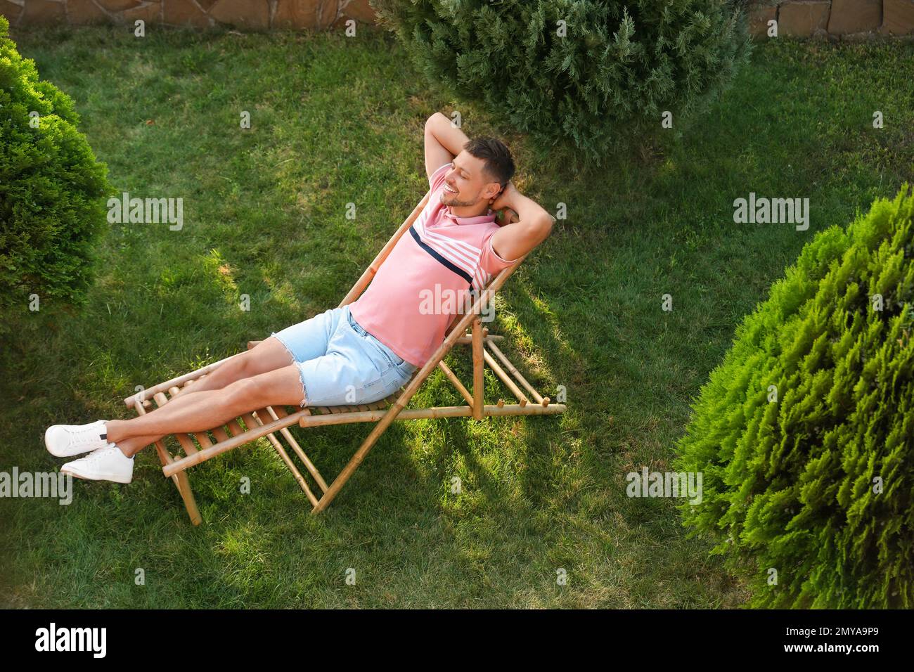 Happy man resting in deck chair outdoors, above view Stock Photo - Alamy