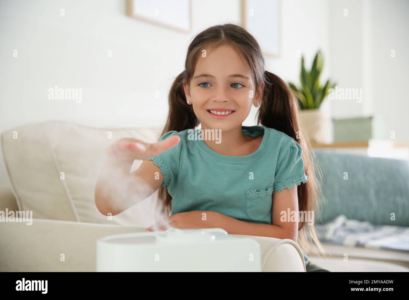 Little girl near modern air humidifier at home Stock Photo - Alamy