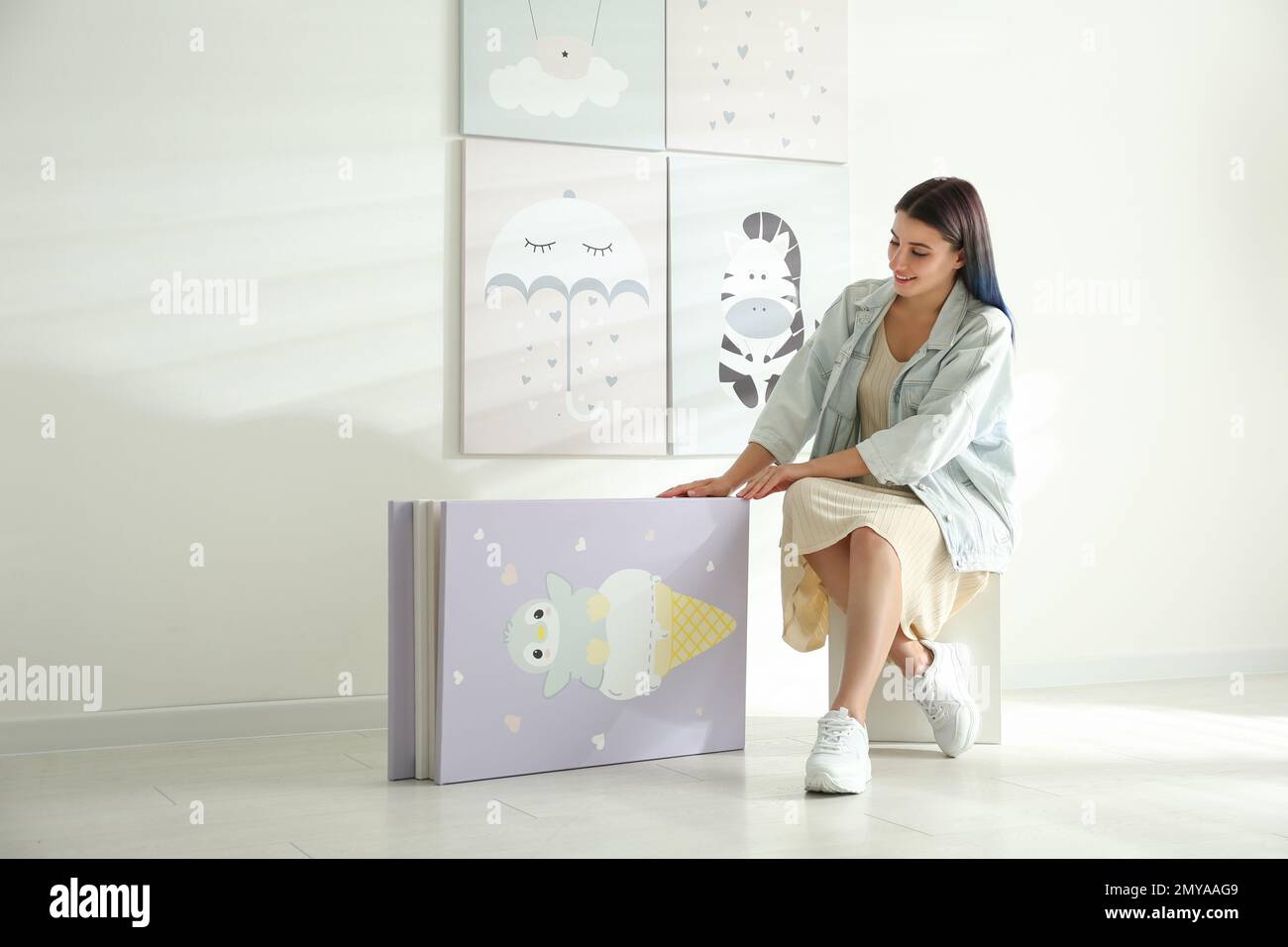 Decorator choosing picture near white wall. Children's room interior ...