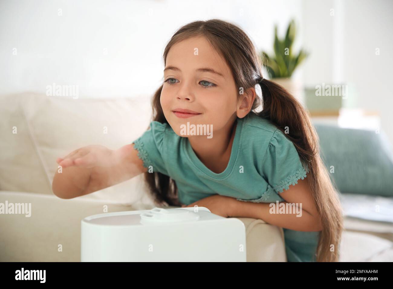 Little girl near modern air humidifier at home Stock Photo - Alamy
