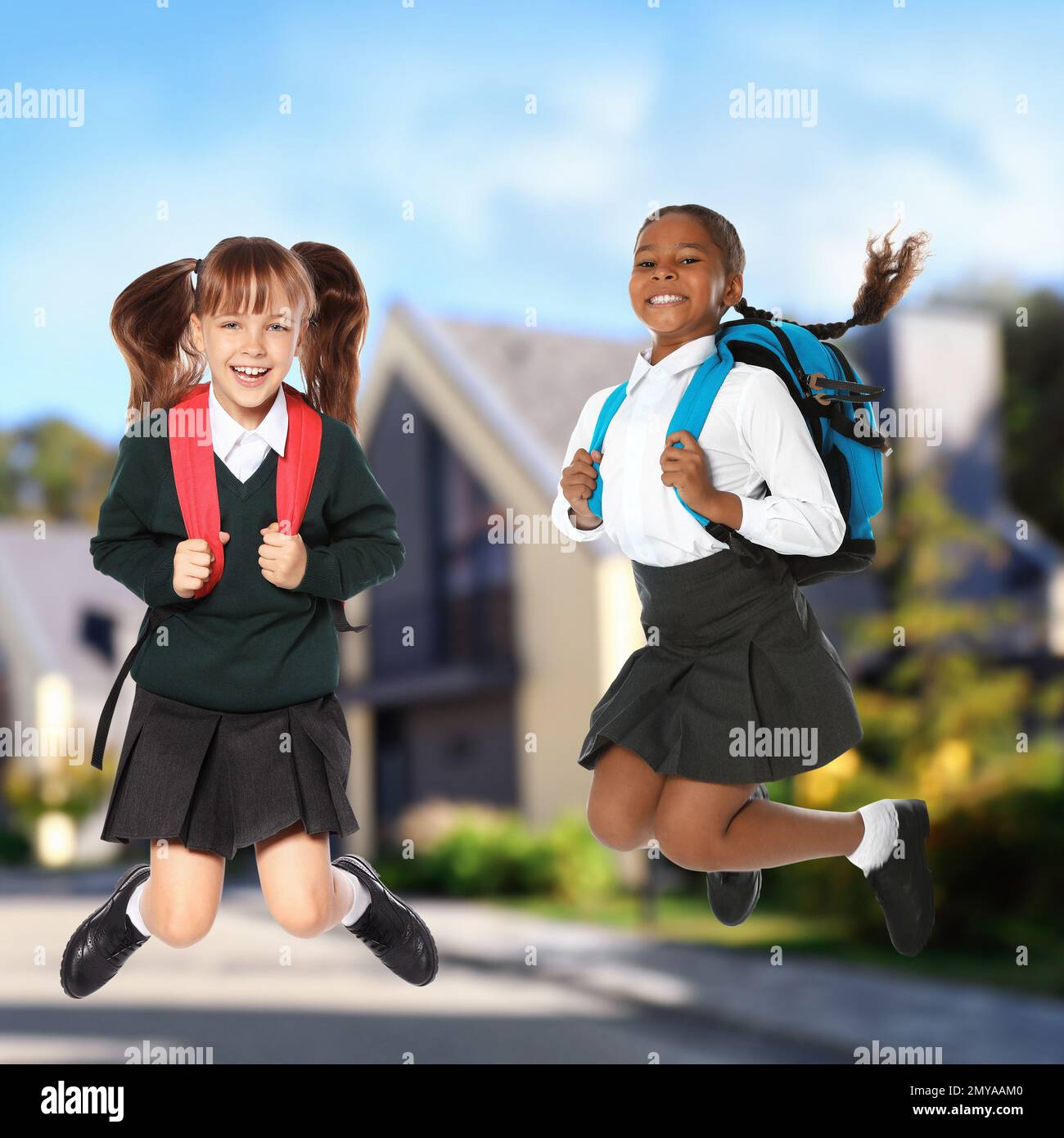 Happy girls jumping near house. School holidays Stock Photo - Alamy