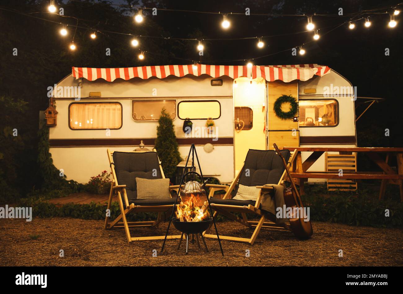 Water heating on open fire near trailer at night. Camping season Stock ...
