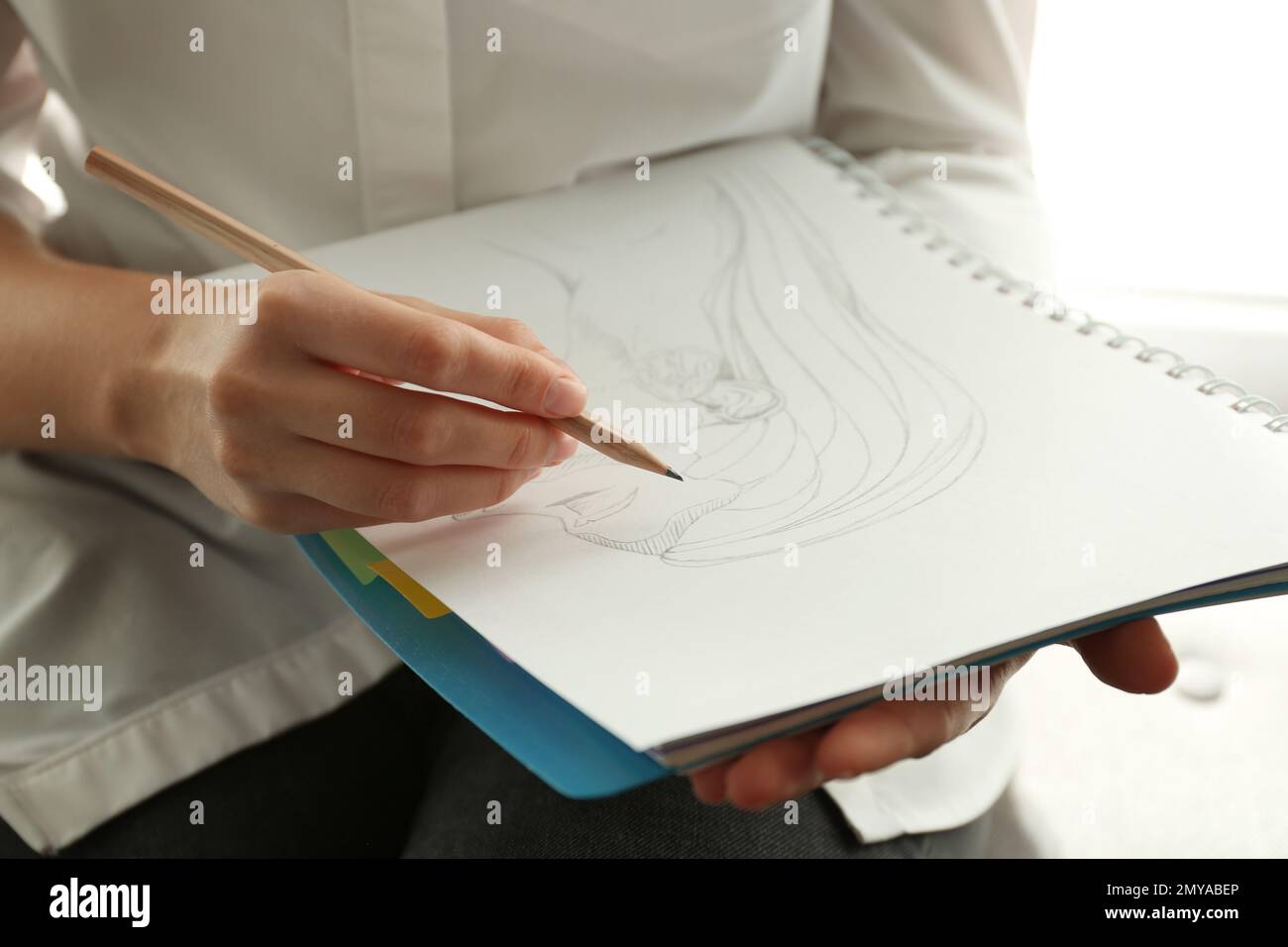 Woman drawing girl's portrait with pencil in notepad, closeup Stock ...