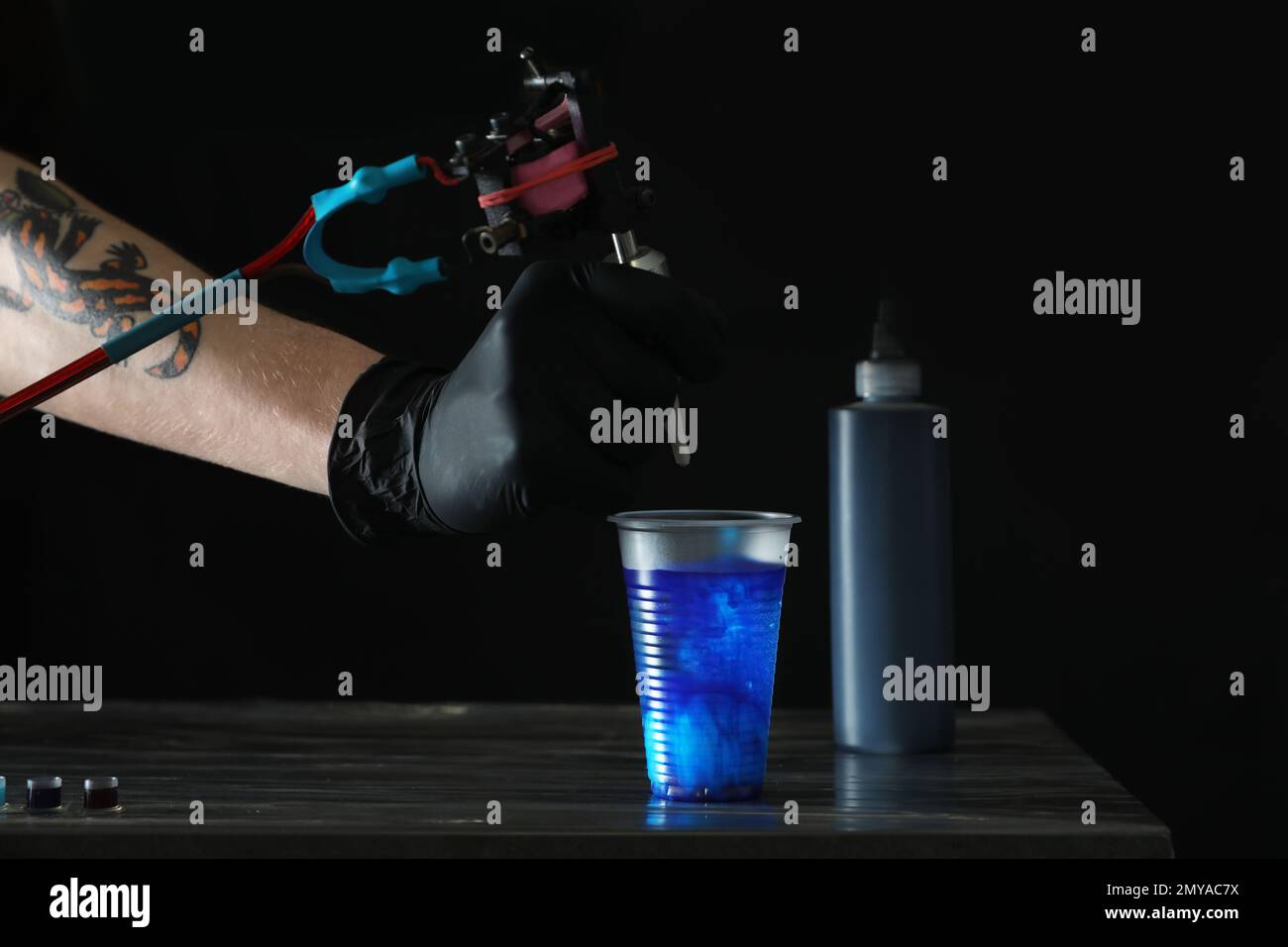 Tattoo artist cleaning machine needle at table, closeup Stock Photo - Alamy