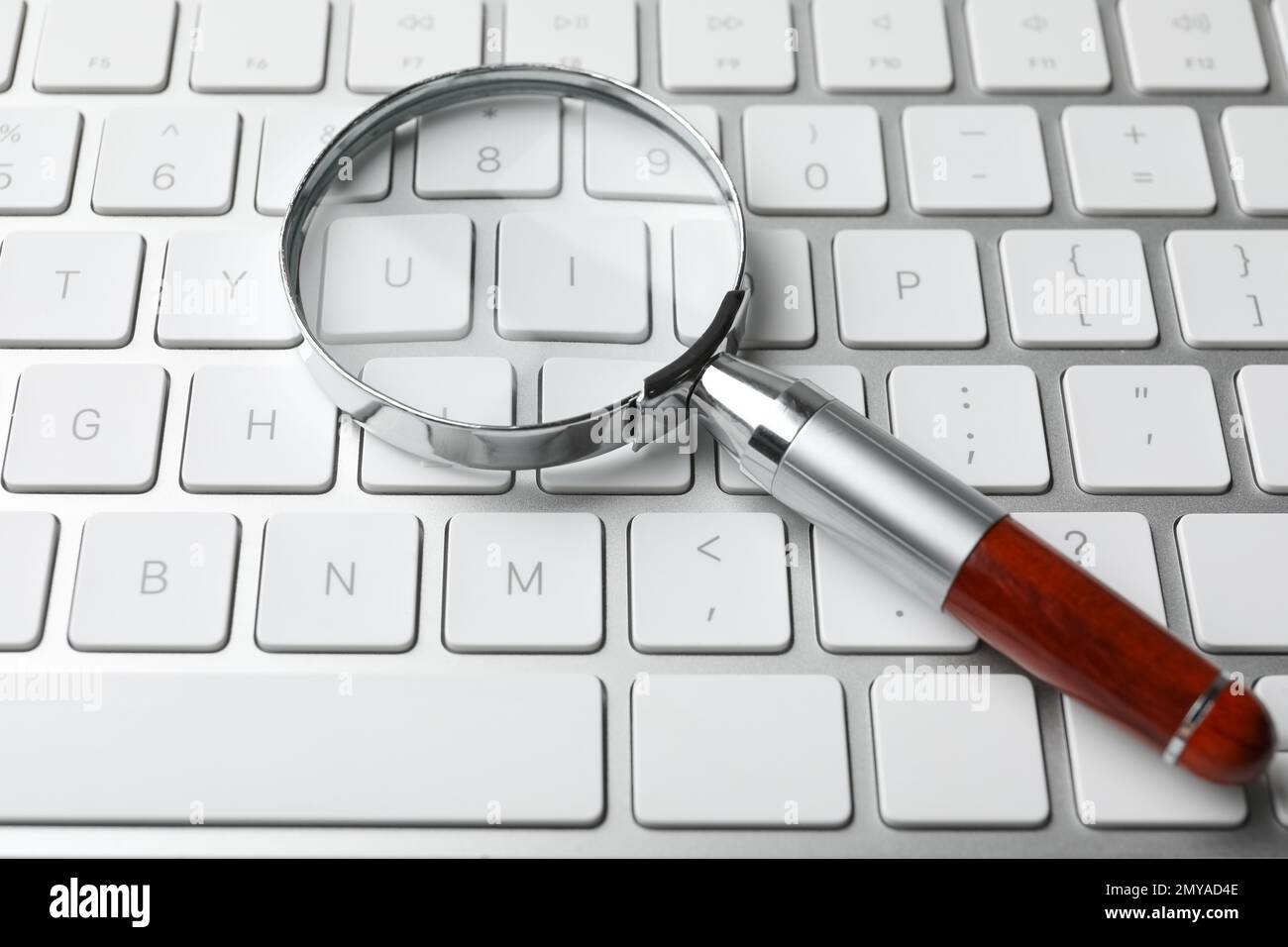 Magnifier glass on modern keyboard, closeup. Find keywords concept ...