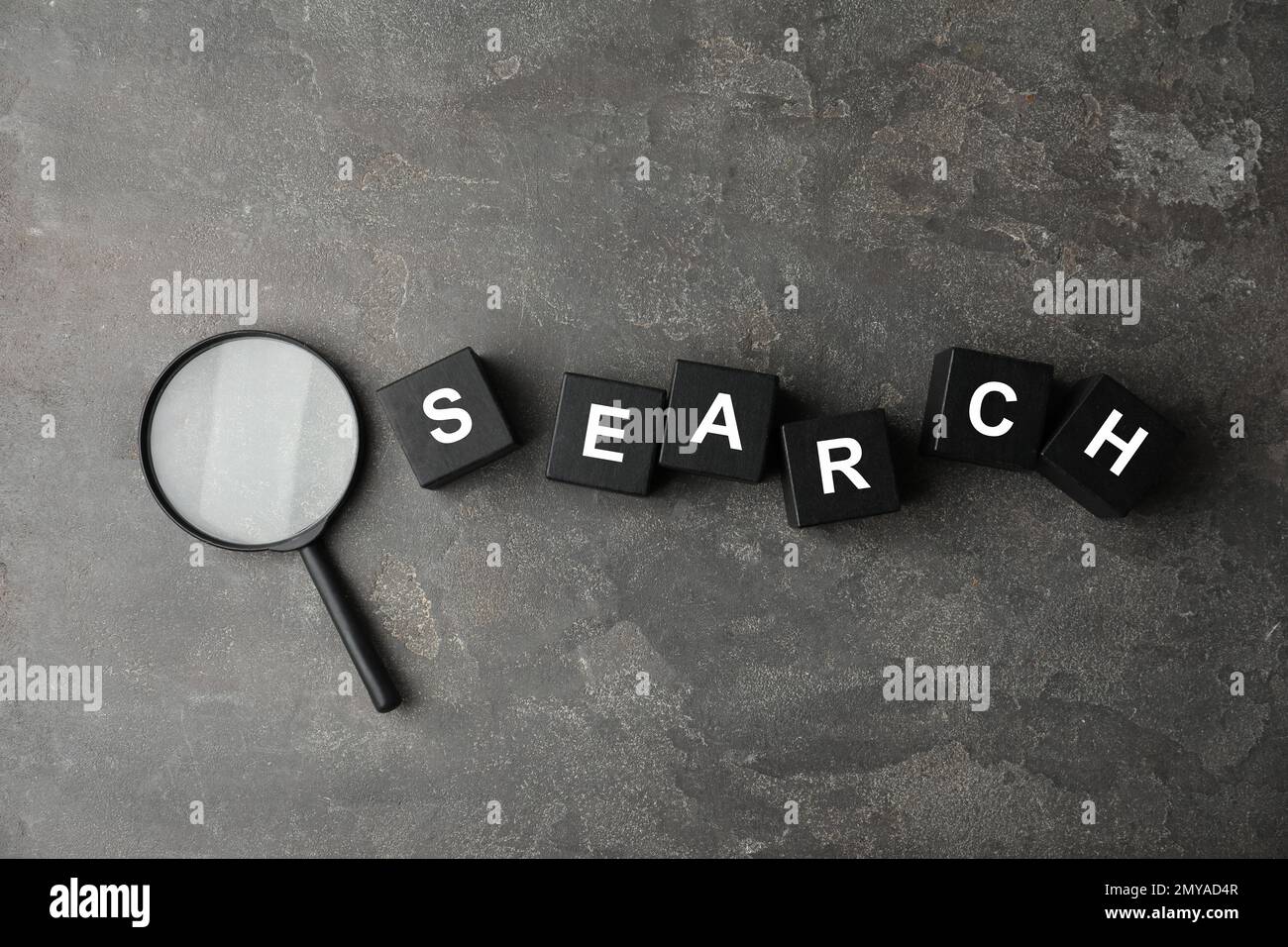 Word SEARCH made of black cubes and magnifier glass on grey stone ...