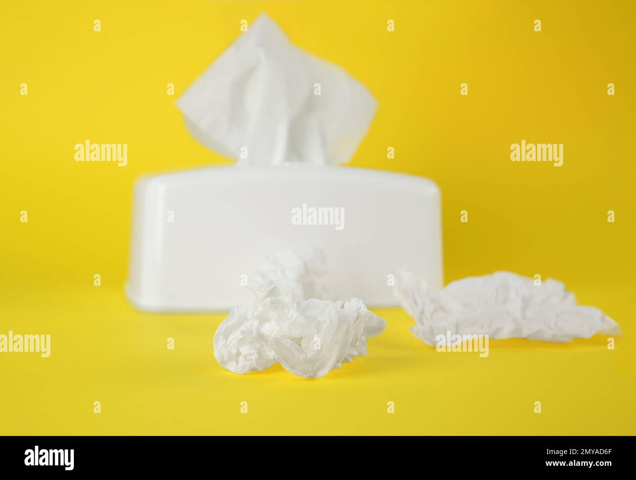 Used paper tissues and white holder on yellow background, closeup Stock ...