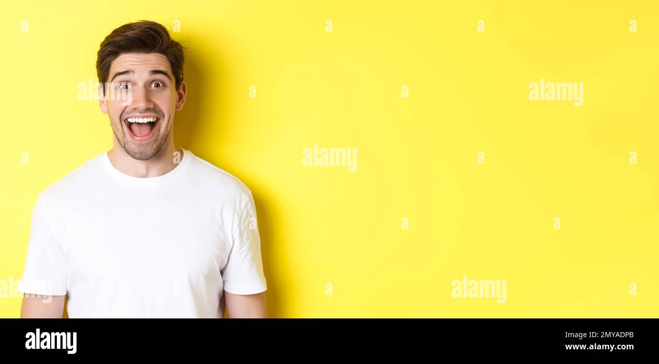 Close-up of surprised handsome guy reacting to great news, standing ...