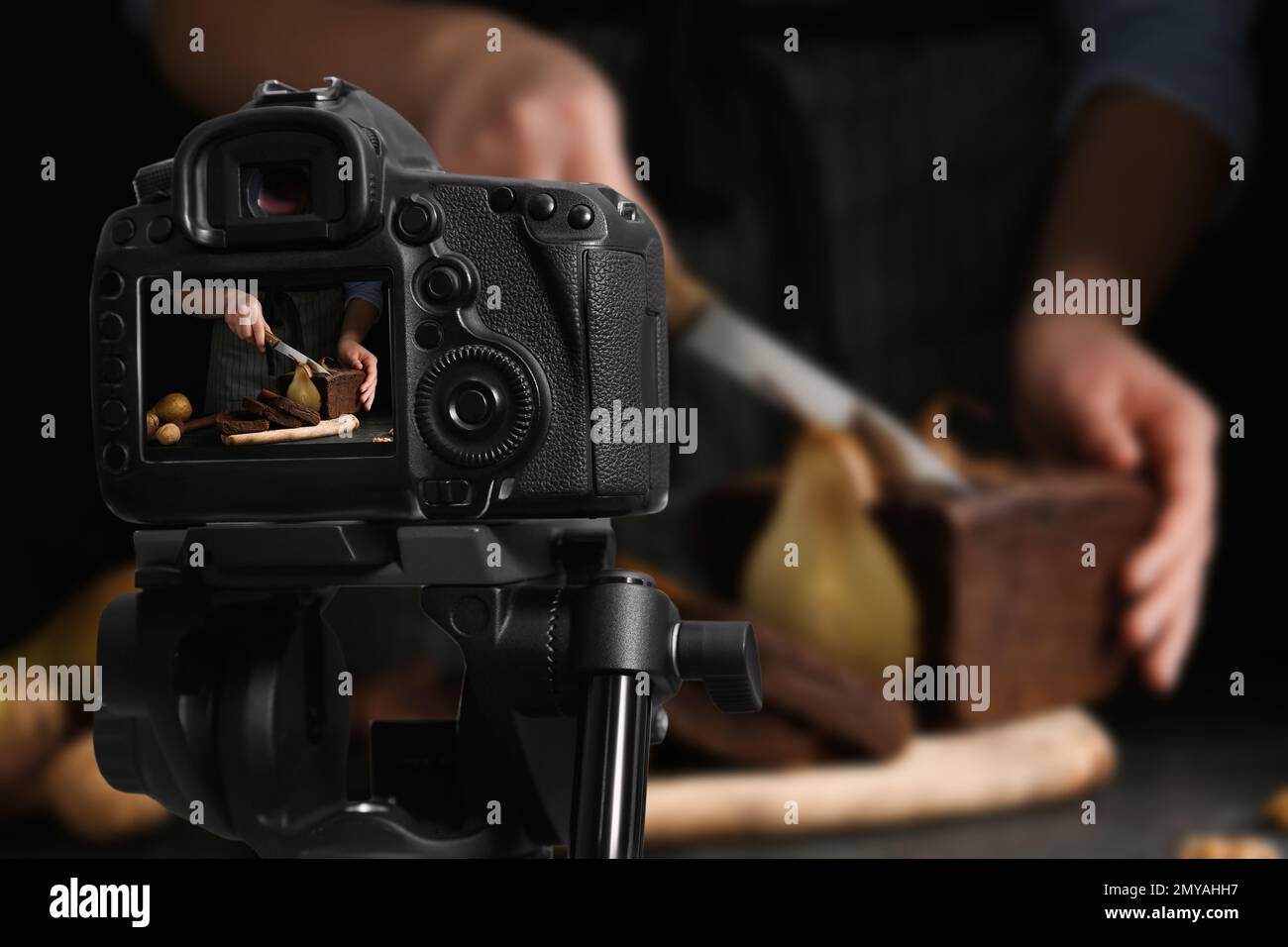 Food photography. Shooting of woman cutting pear bread, focus on camera ...