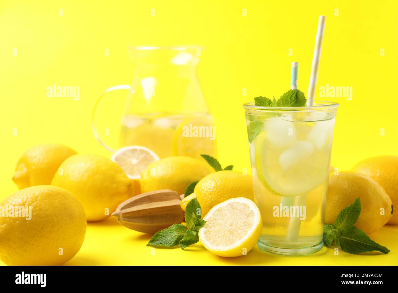 Natural freshly made lemonade with squeezer on yellow background ...