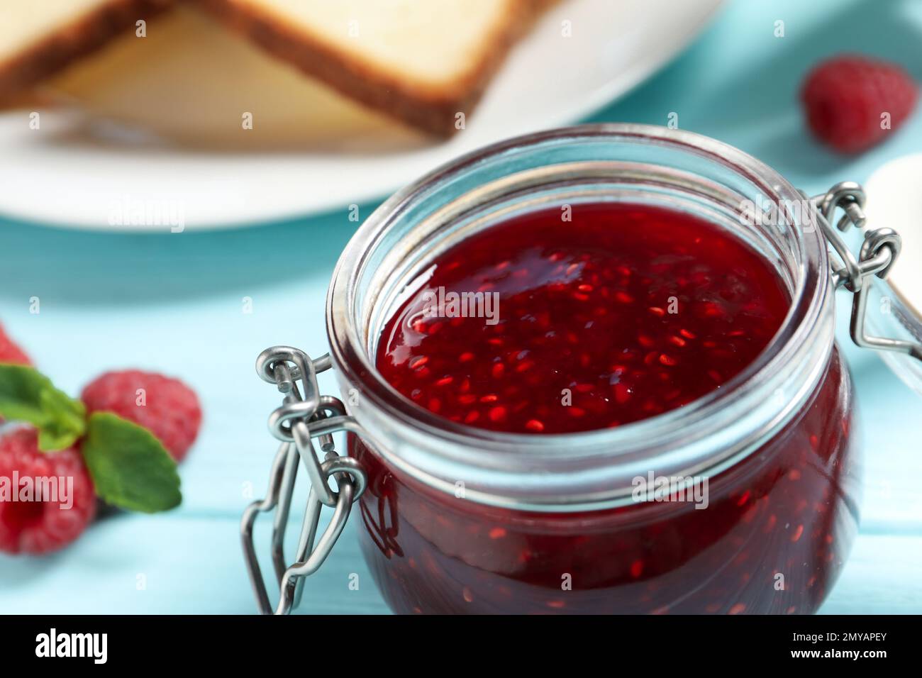 Sweet raspberry jam for breakfast on turquoise table, closeup Stock ...