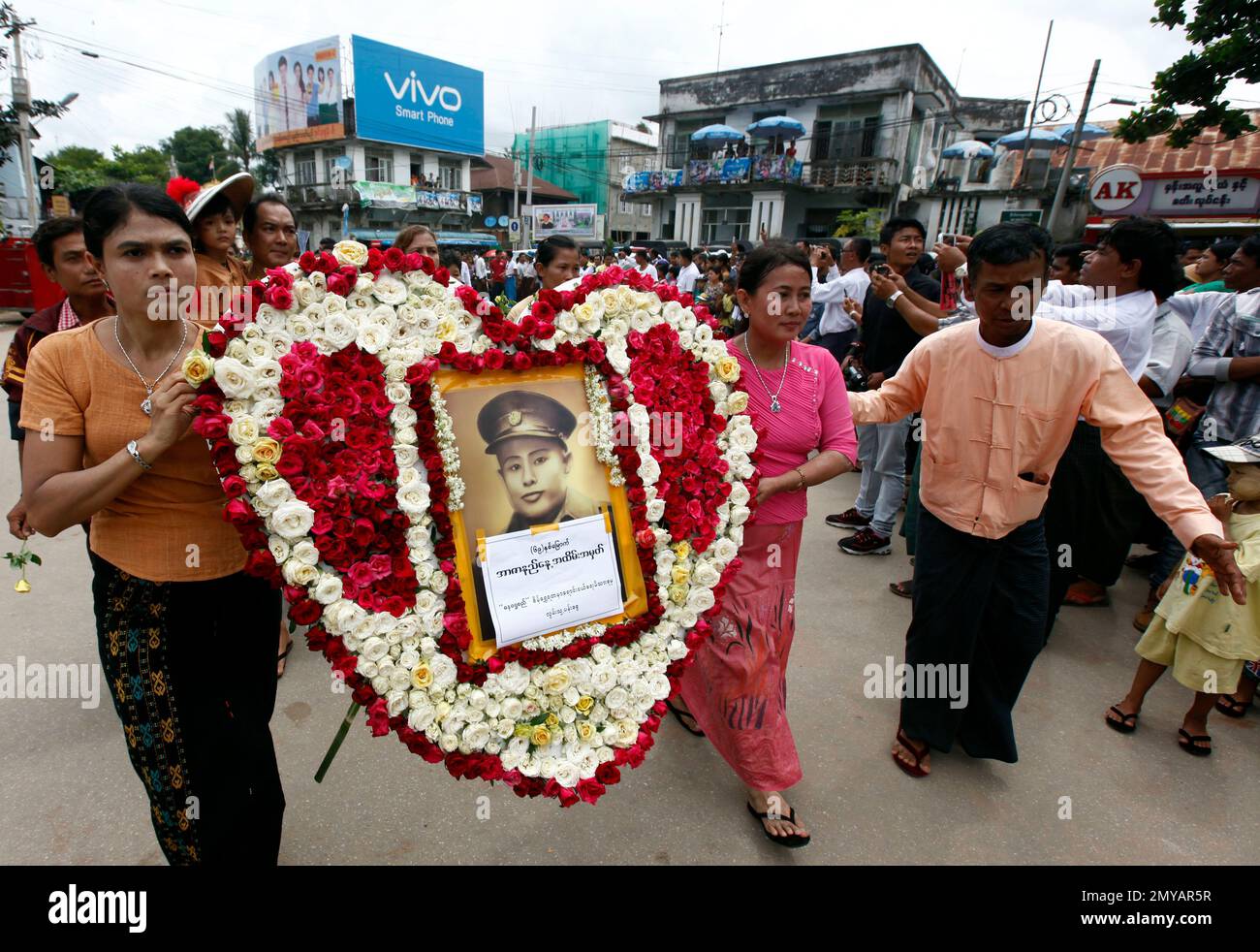 People march with the wreath to the tomb of Gen. Aung San, his image ...