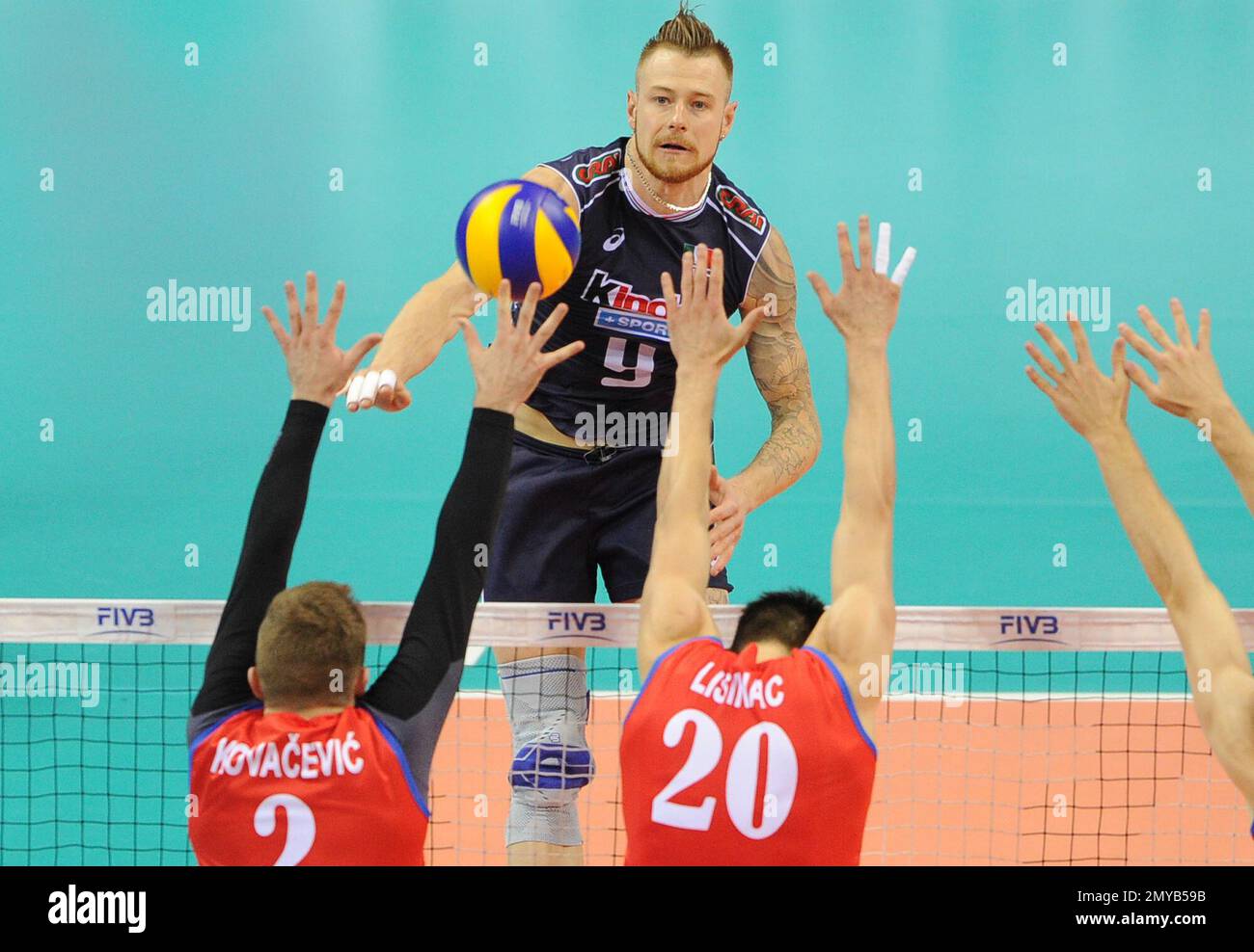 Italy's Ivan Zaytsev, center,spikes the ball against during Sebia's ...