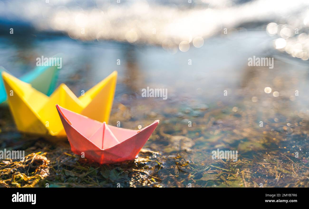 Multicolored paper boats. Colorful pink yellow blue orange ships in big ...