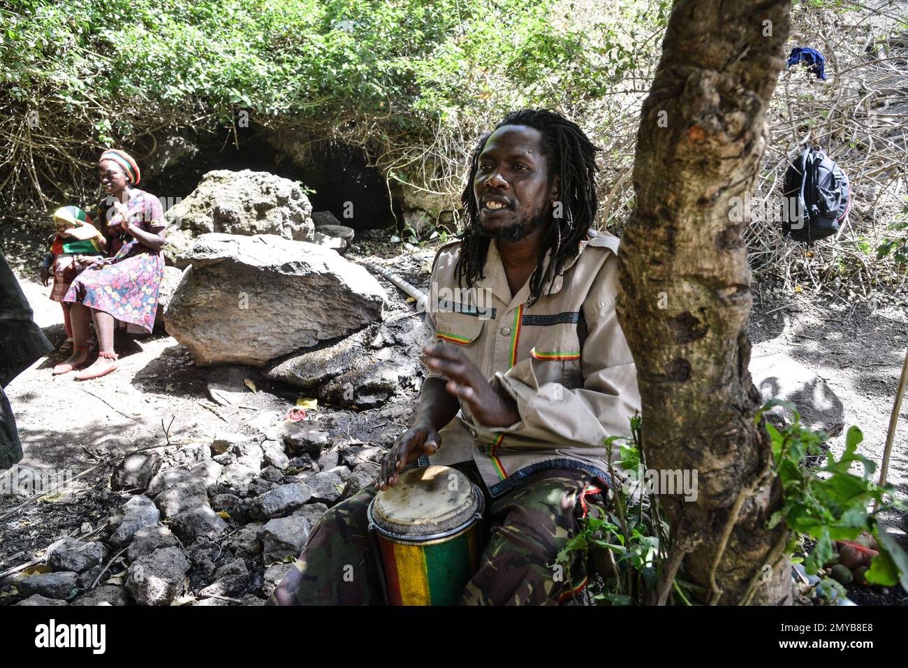 An adherent of the Rastafari sect plays a drum and sings during the ...