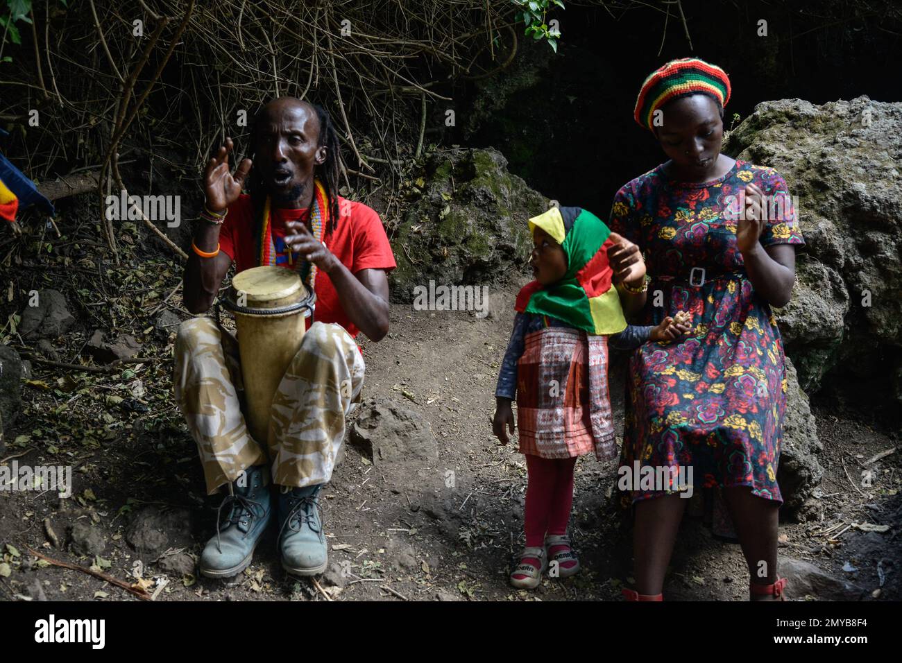 Adherents of the Rastafari sect play a drum and sing during the group's ...