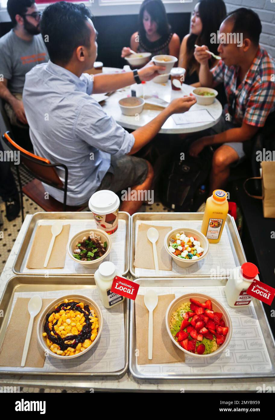 Patrons eat cereal near a sampling display of cereal served at the new ...