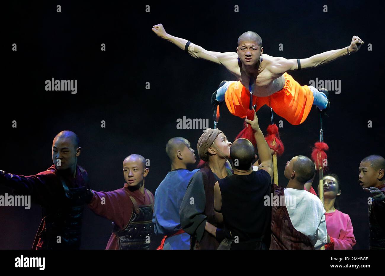 A Shaolin monk is propped up by spears during a media preview of ...