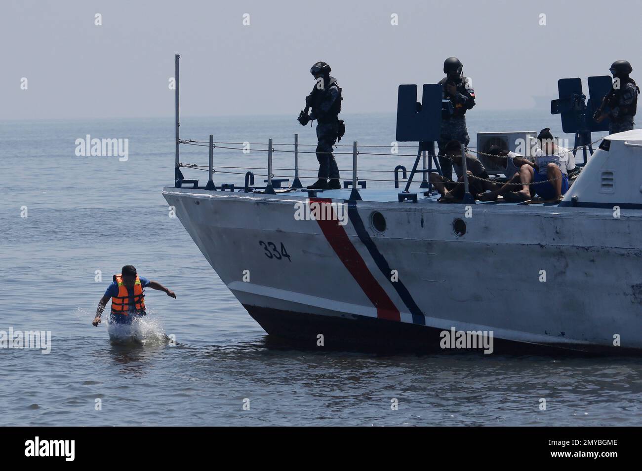 A Filipino acting as a pirate jumps from a ship as part of a combined ...