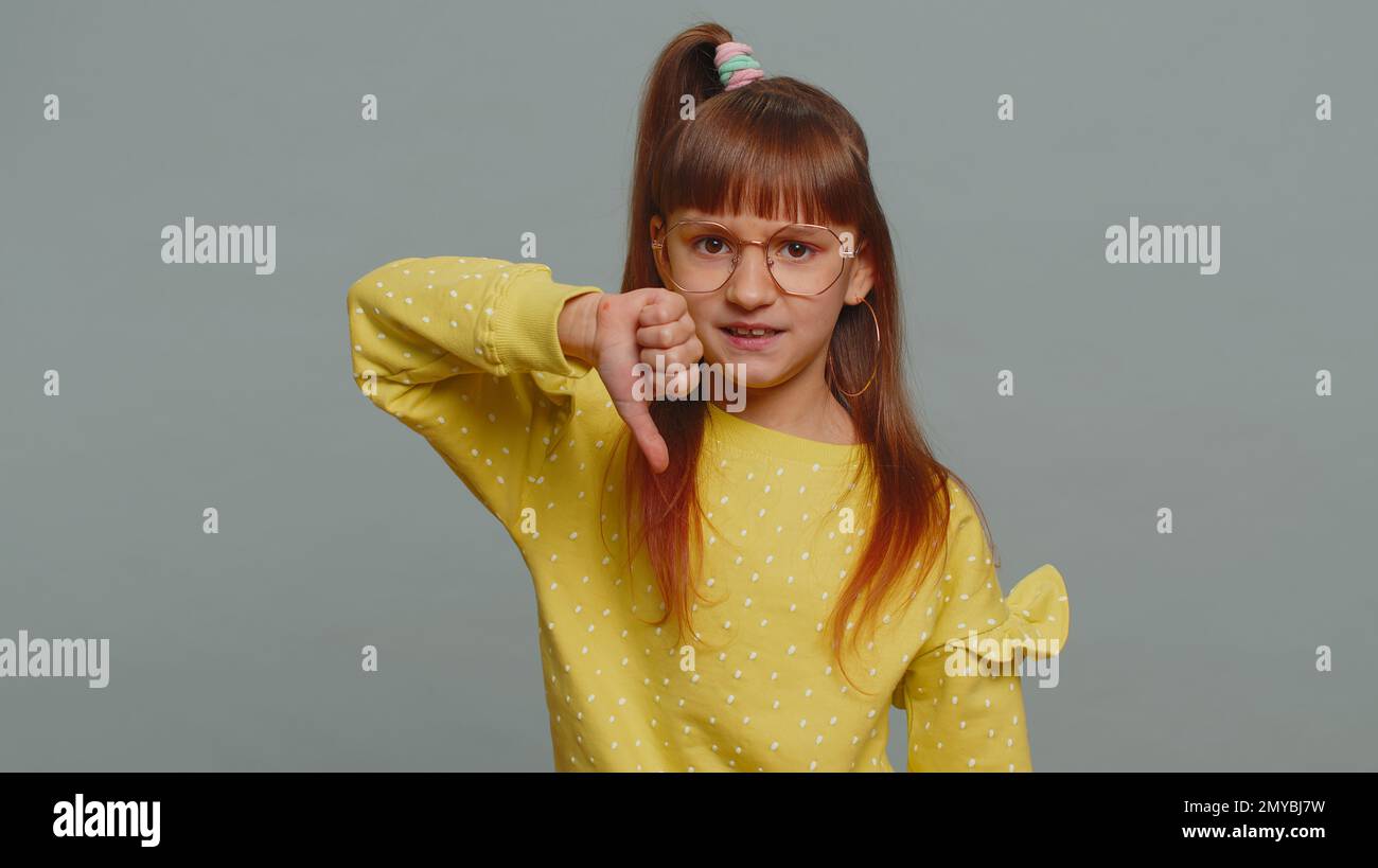 Dislike. Upset young preteen child girl kid showing thumbs down sign ...