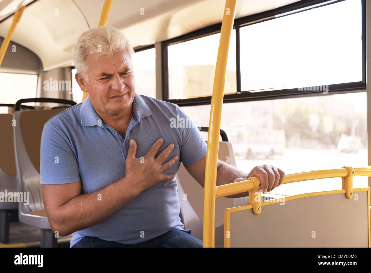Senior man having heart attack in public transport Stock Photo - Alamy