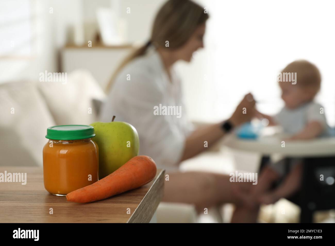 Mother with her little baby at home, focus on healthy puree and fresh ...