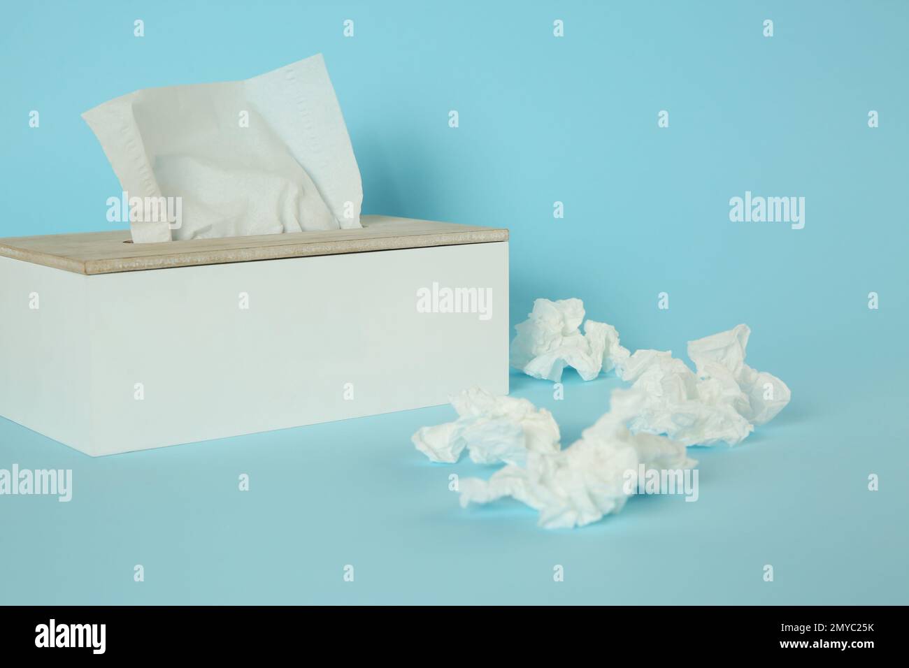 Used paper tissues and holder on light blue background Stock Photo - Alamy