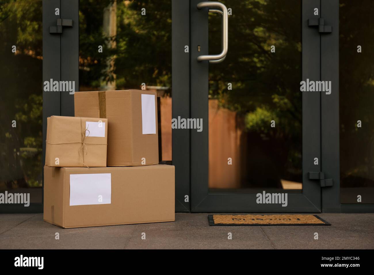 Delivered parcels on porch near front door Stock Photo - Alamy