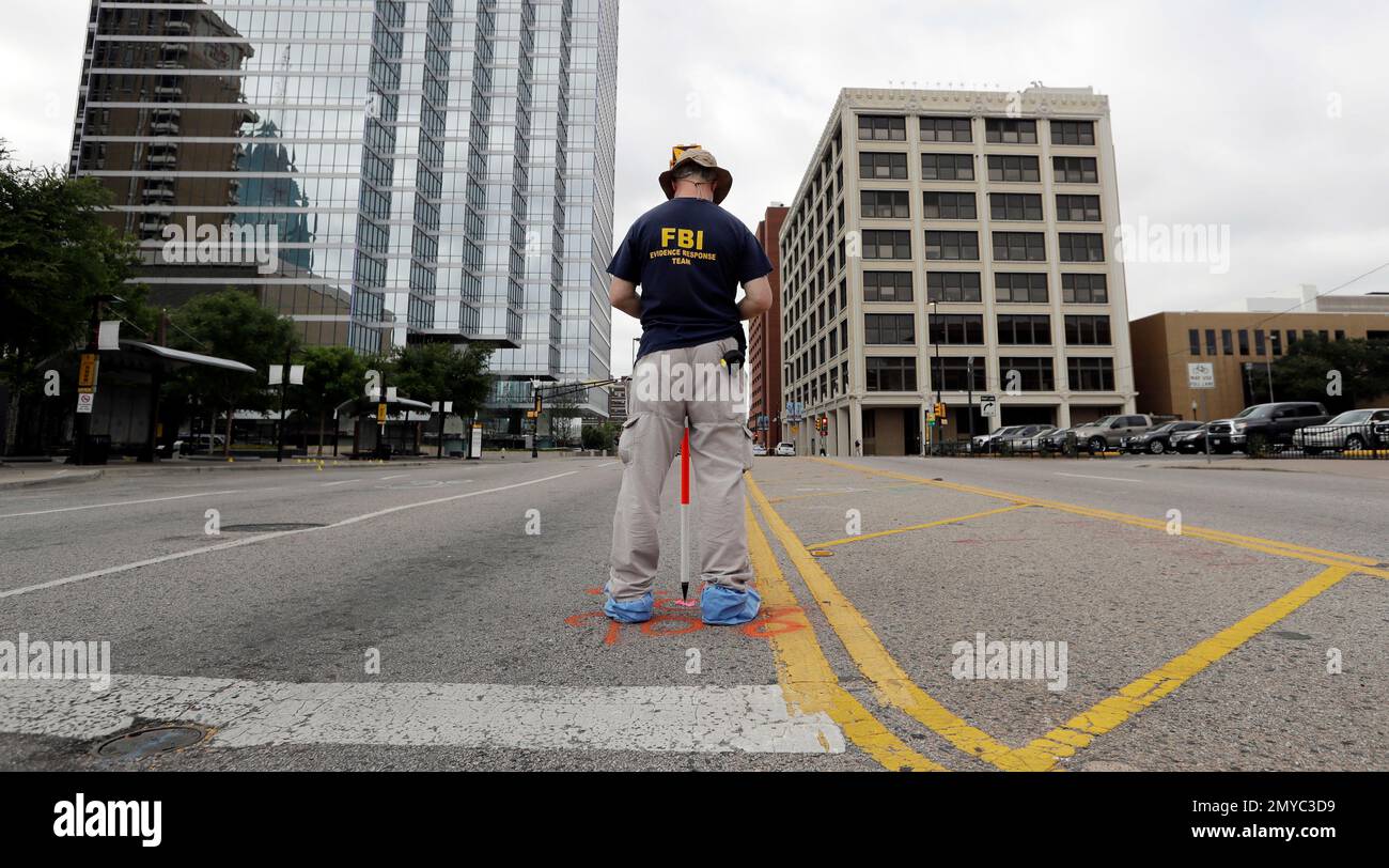 Investigators work in the area of downtown Dallas that remains an ...
