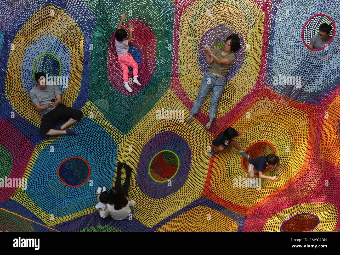 Visitors enjoy a mega hand-knitted crocheted playscape created by ...