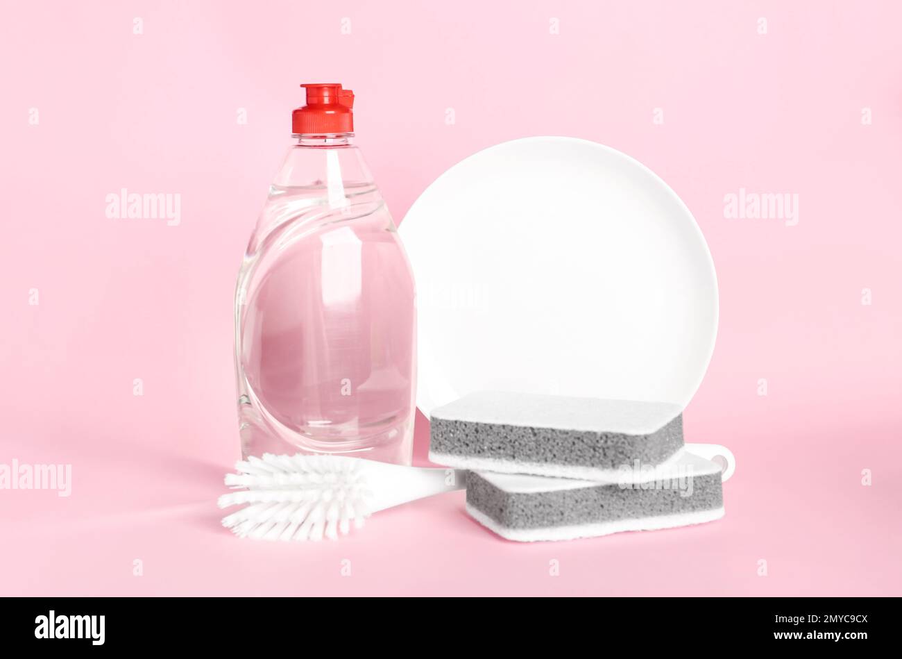 Detergent, plate and sponges on pink background. Clean dishes Stock ...