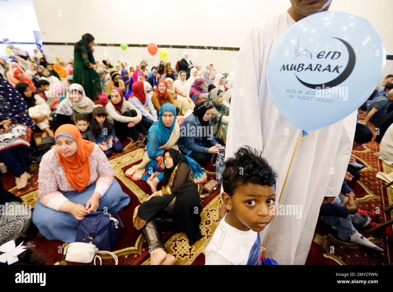 A child holds a balloon with a Muslim greeting used during the Eid-al ...